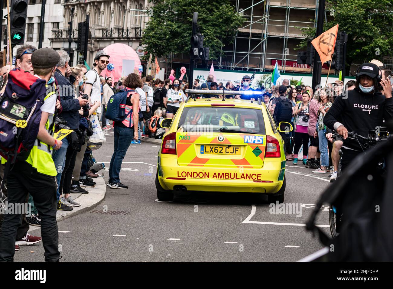 London,UK-28 Aug 2021: Ambulance passing through a large group of ...