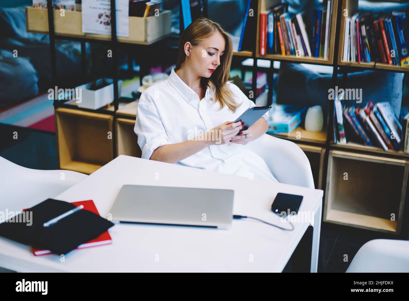 Focused woman using tablet in workspace Stock Photo - Alamy