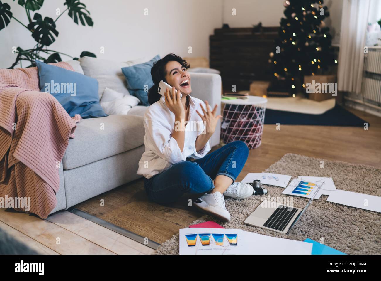Expressive female friends having phone call while studying at home ...