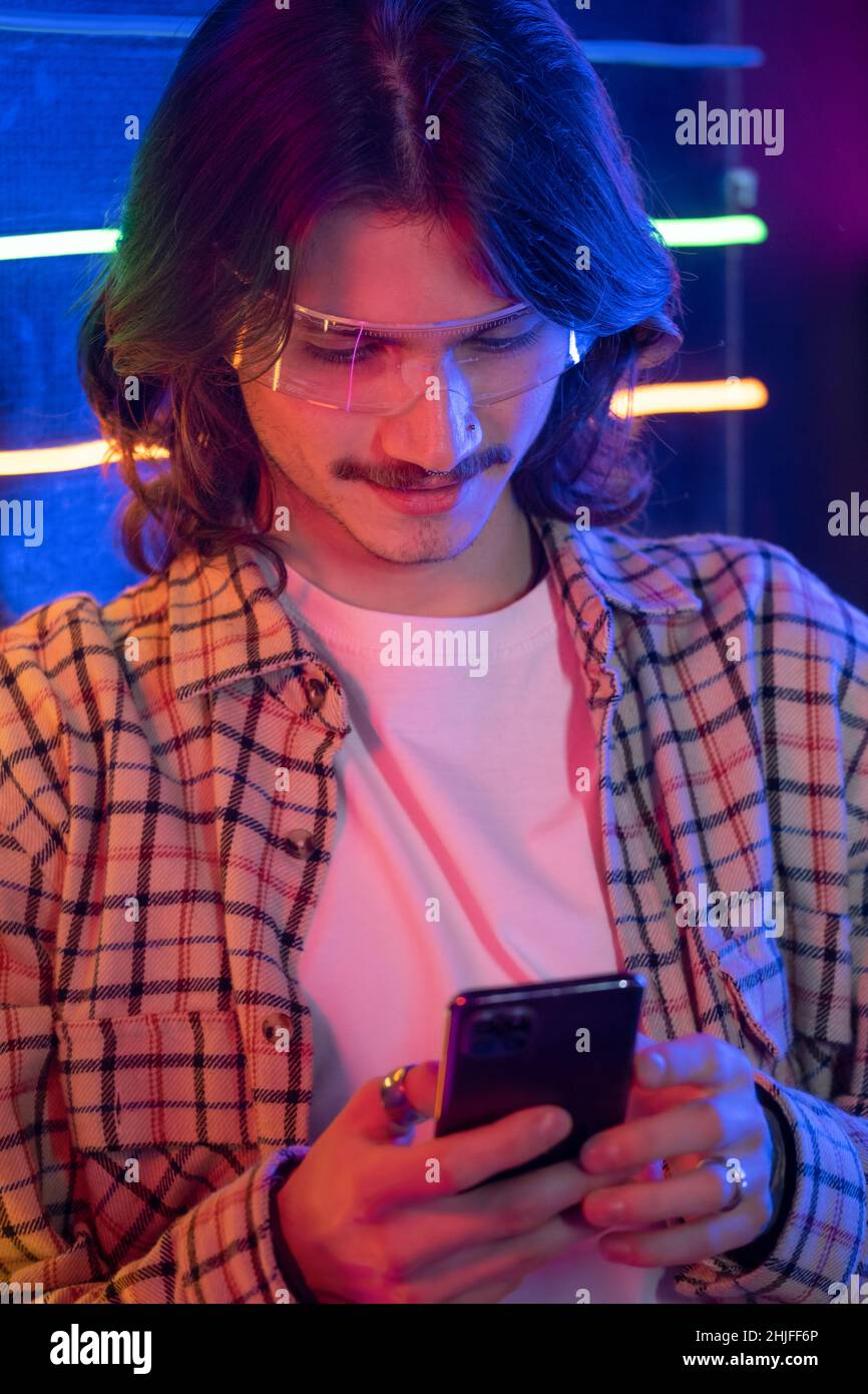 Millennial man in old phone box using smartphone and enjoying retro ...