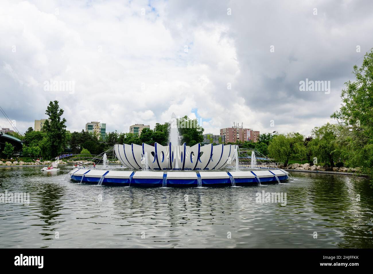 Landscape with the lake, decorative fountain and vivid green trees in ...