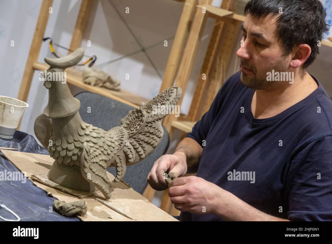 Moscow, Russia. 18th December, 2021 A master sculpts a toy out of clay ...