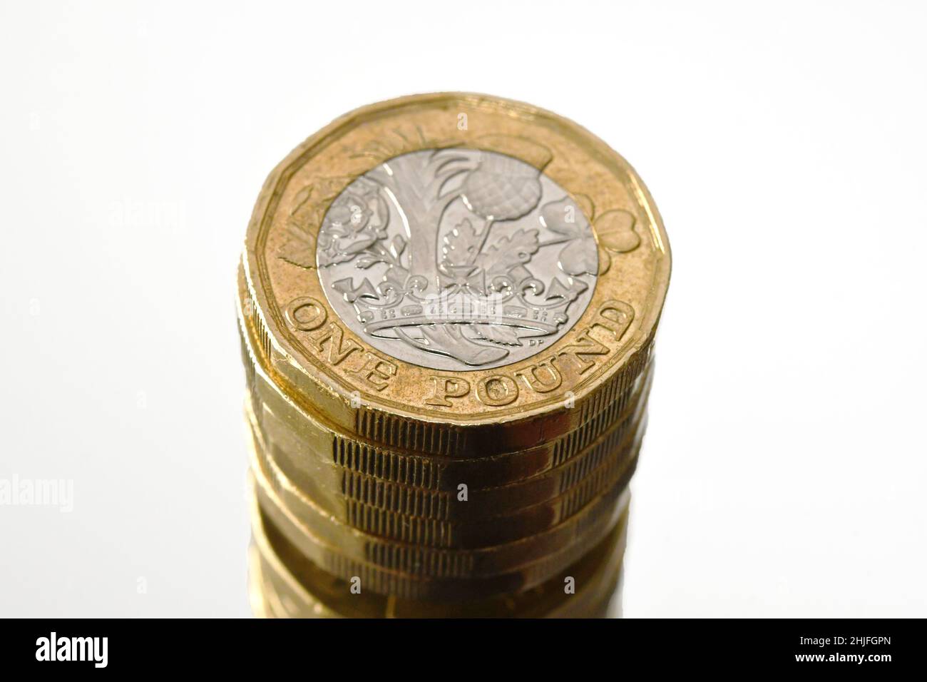 Close up of a column of one pound coins isolated on a plain white ...