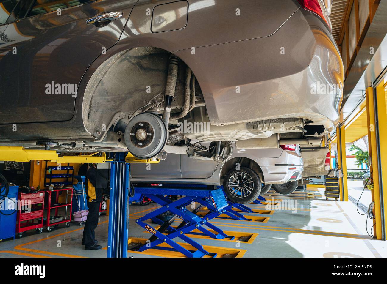 Damaged car and dirty disc brake lifting for maintenance in garage ...