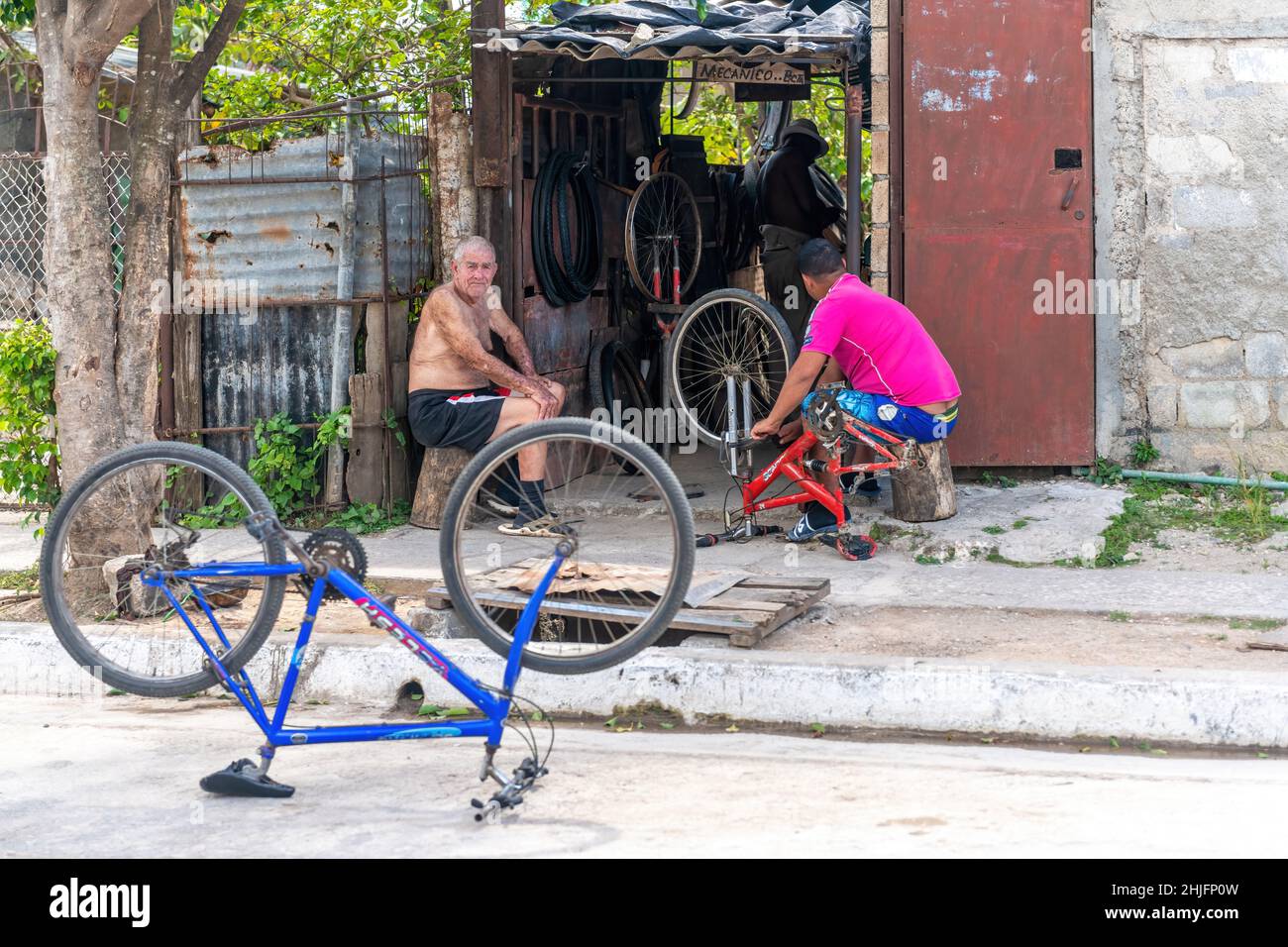 A bicycle repair shop in the La Vigia neighborhood. Two men sit at the ...