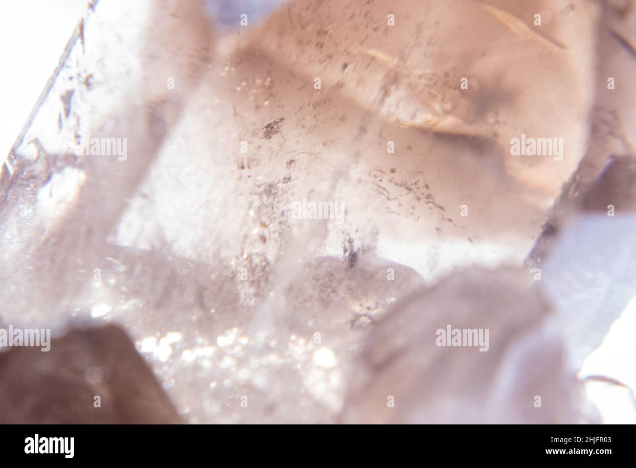 Closeup of a rough clear quartz crystal under the lights with a blurry ...