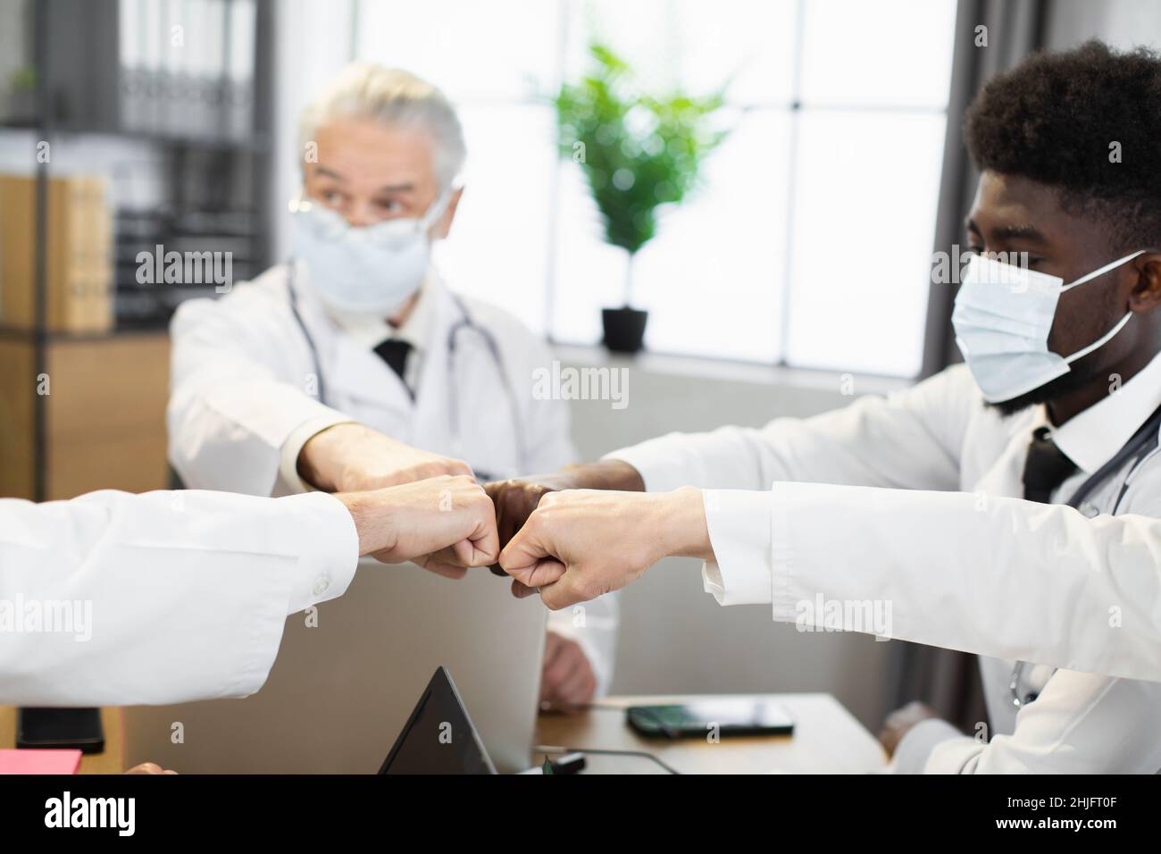 Close up pf male and female medical specialists using fist bump for ...