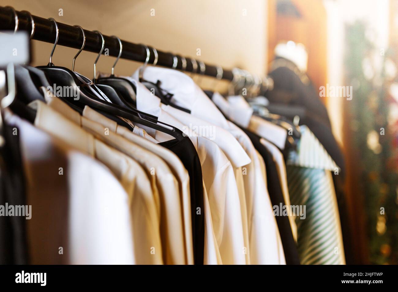 Clothes hang on a shelf in clothes store. Clothes for women hanging on ...