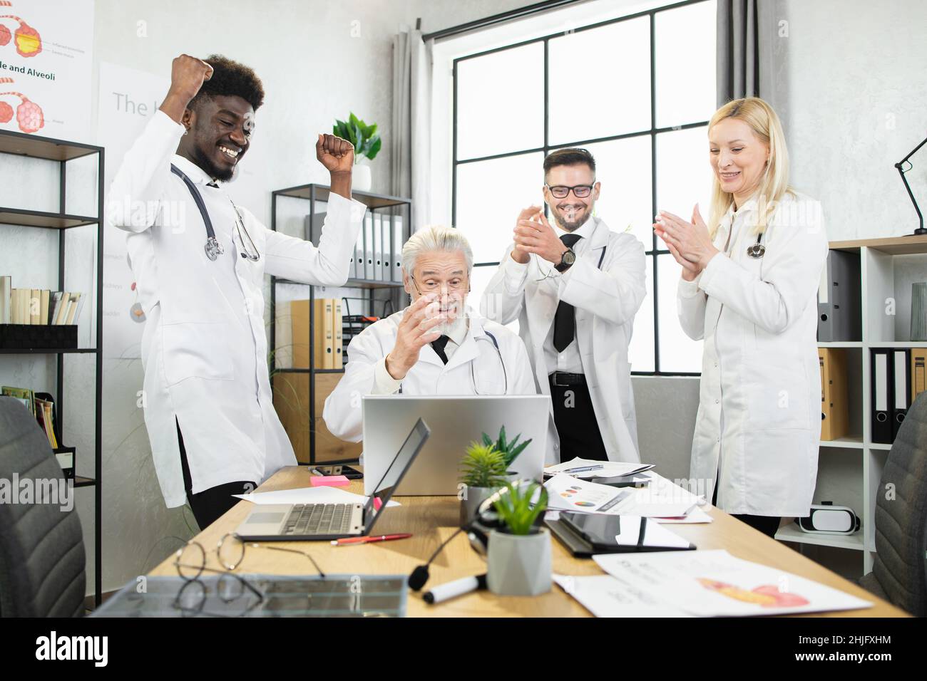 Group of multicultural doctors smiling and clapping in hands while ...