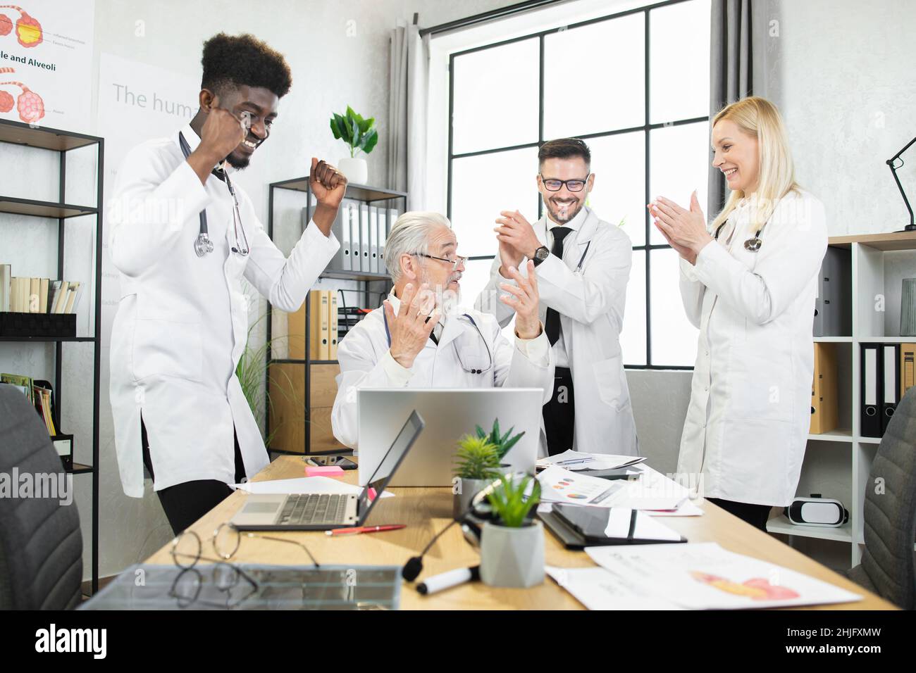 Group of multicultural doctors smiling and clapping in hands while ...