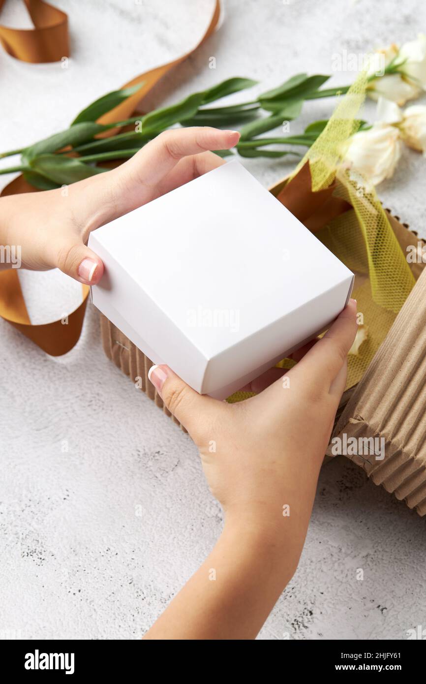 Photo showing a person's hands opening a gift box and other stuff on a ...