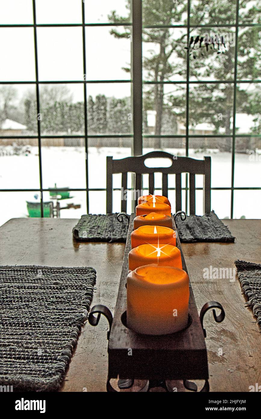 View from kitchen window with candles lit on table of snowy scene ...
