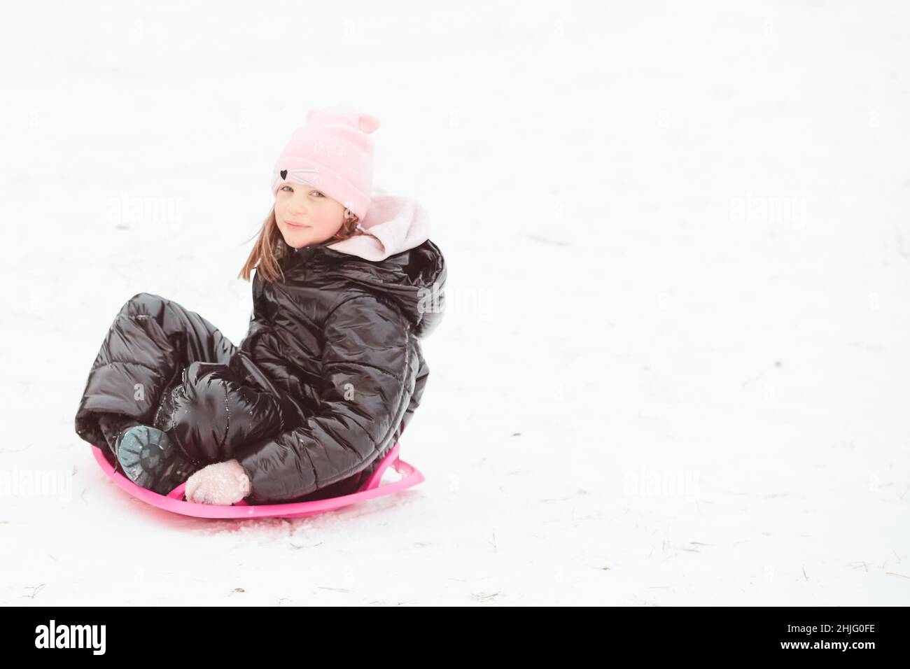 Active girl sliding down the hill. Happy child having fun outdoors in ...