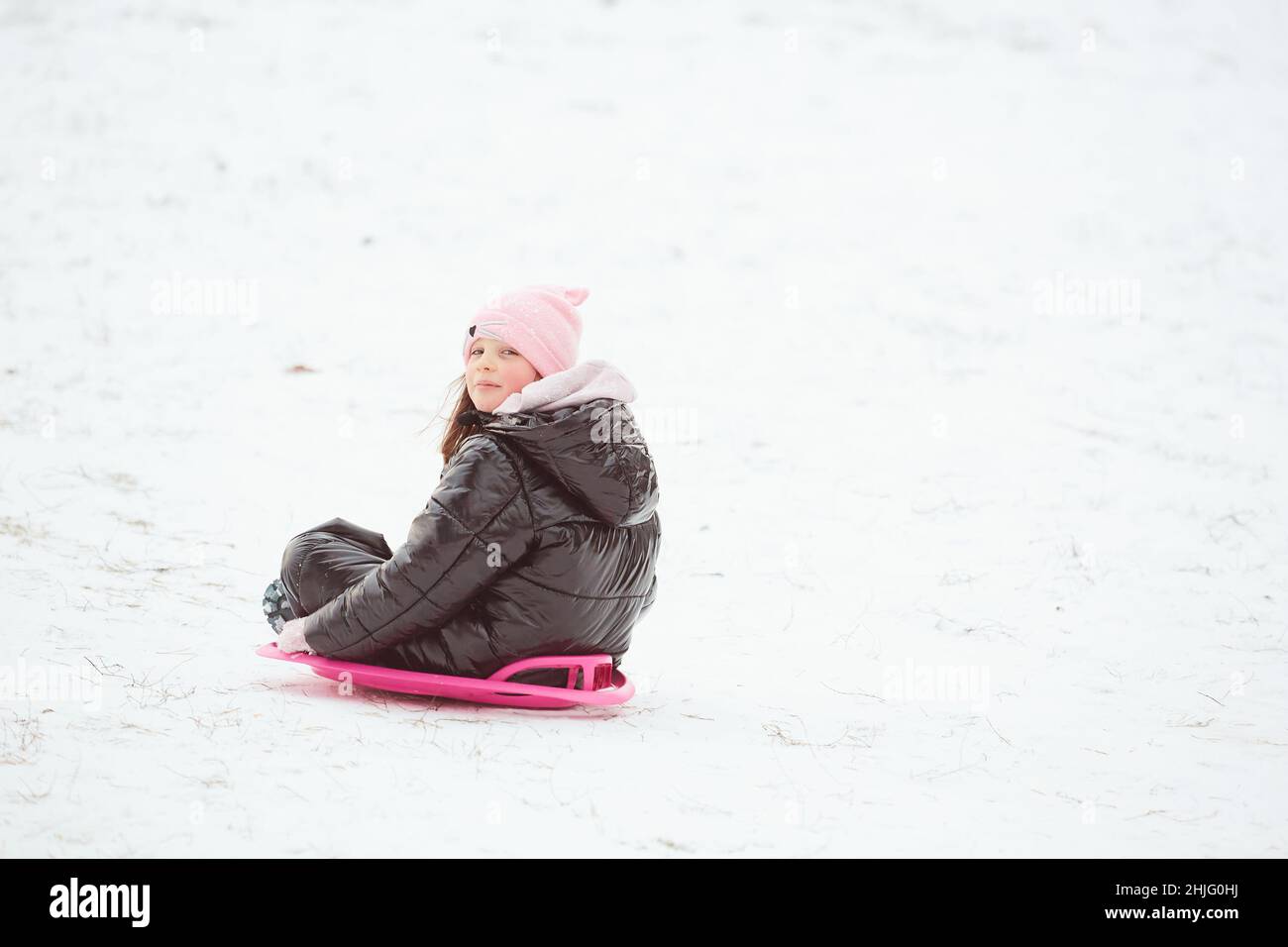 Active girl sliding down the hill. Happy child having fun outdoors in ...