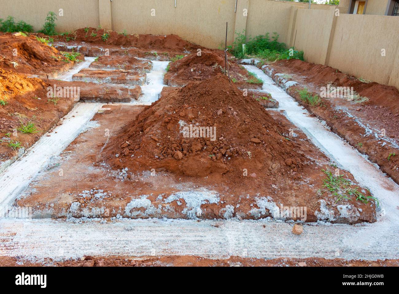 Concrete filled trenches of the foundations of a building that is about ...