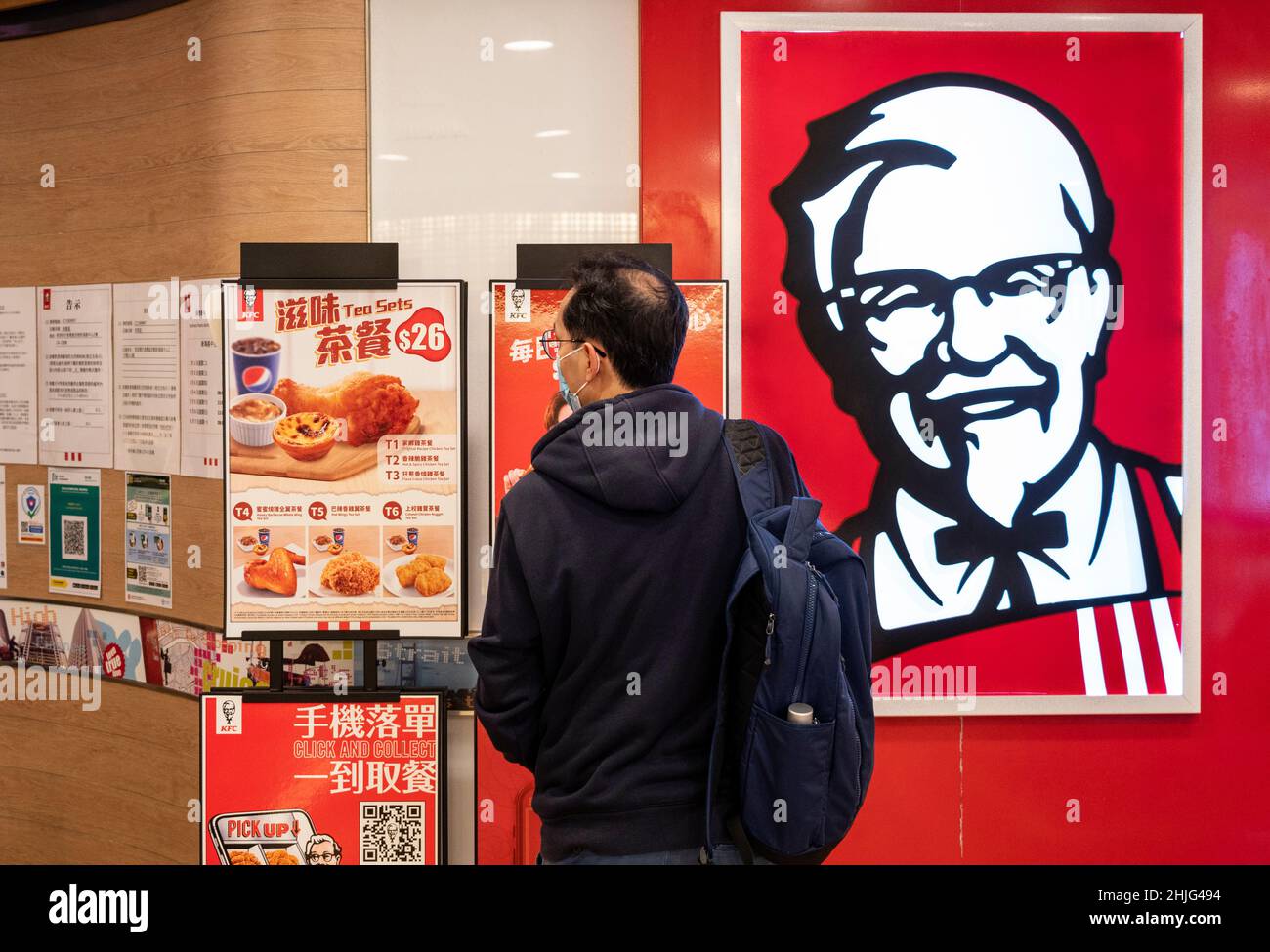 A customer studies the food menu at the American fast food chicken ...