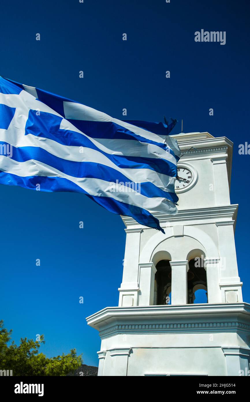 Clock Tower with a developing flag of Greece on the island of Poros in ...