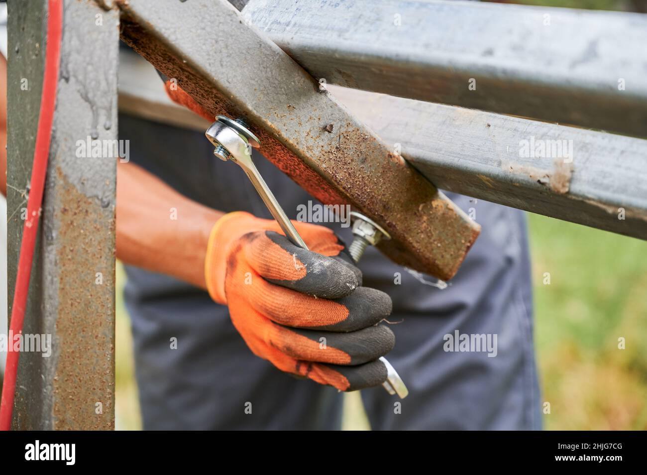 Close up of man hand in work glove tightening bolt with stainless steel ...
