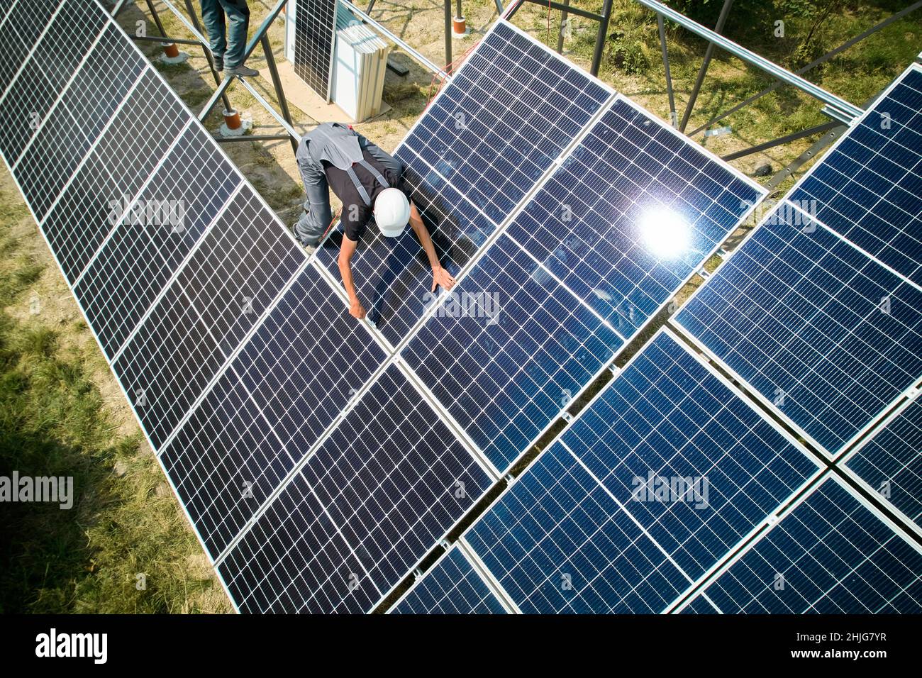 Aerial view of man technician installing solar panels to high steel ...
