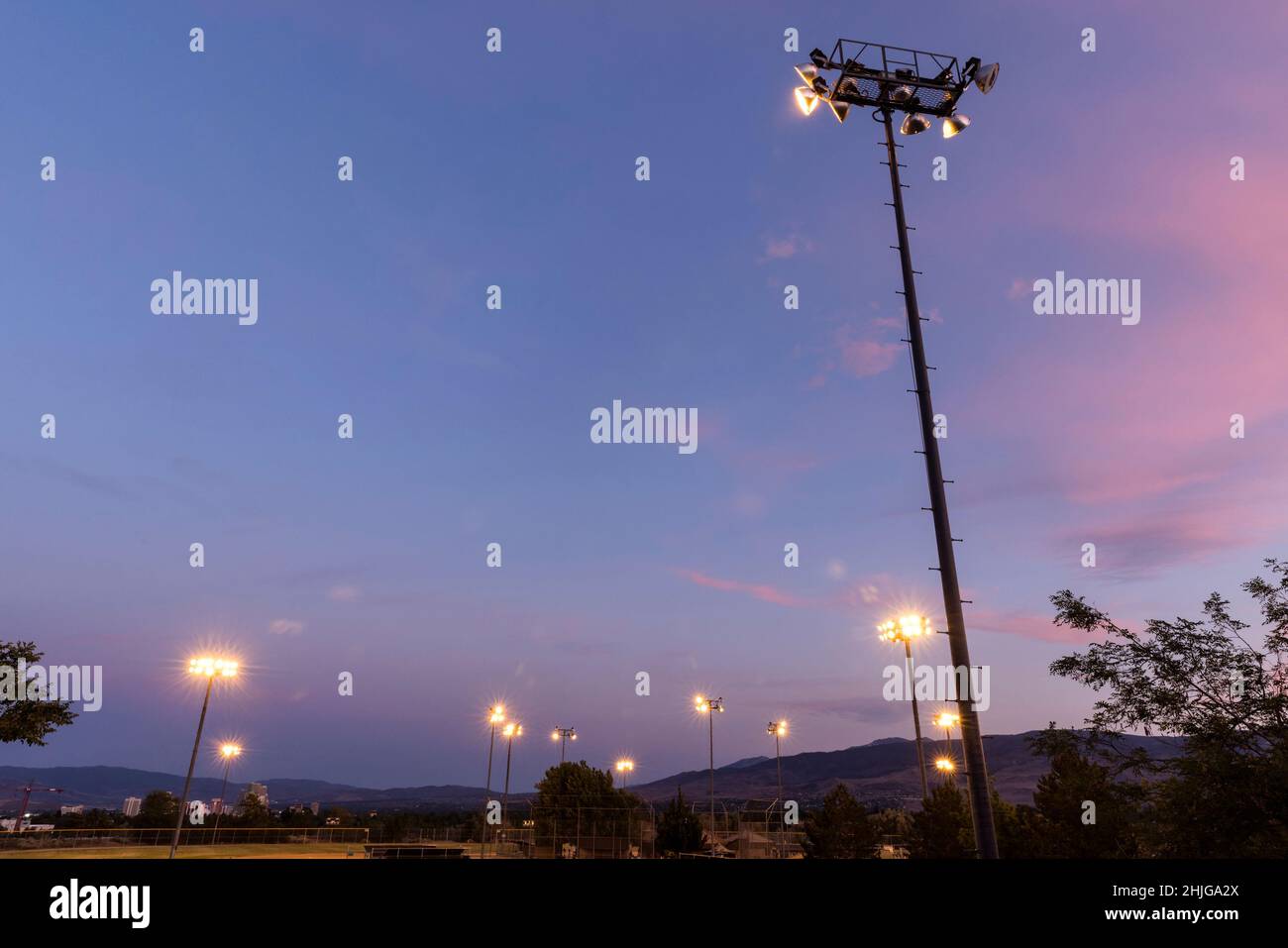 Tall stadium light pole over a baseball field at sunset Stock Photo - Alamy