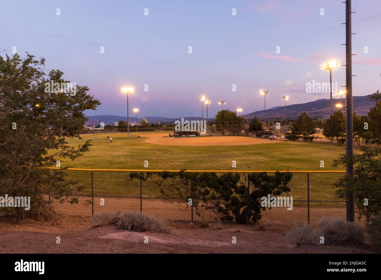 Baseball field in the evening with players playing a game Stock Photo ...