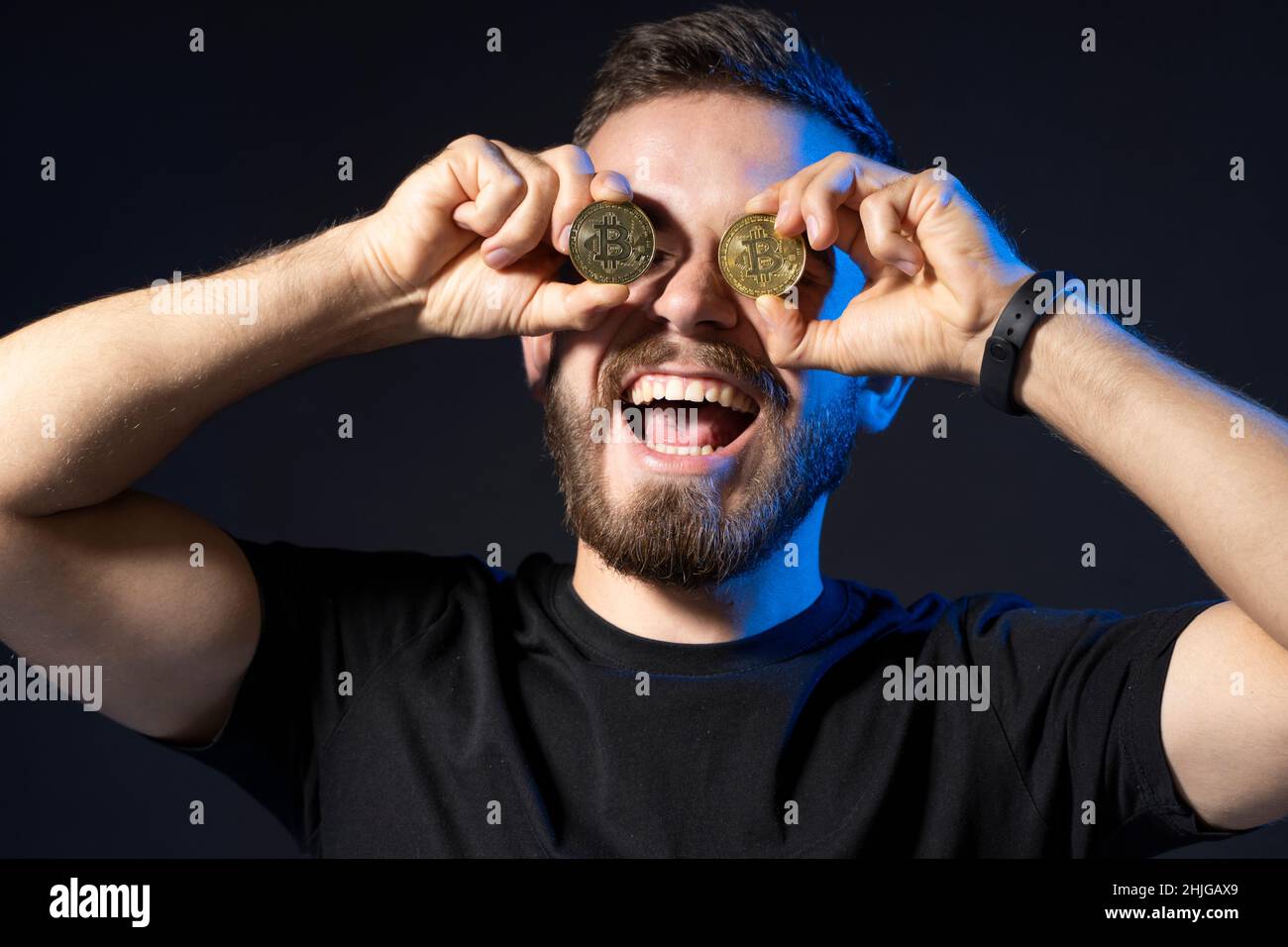 Crazy happy bitcoin lover with golden coin by eyes. Digital symbol of a ...