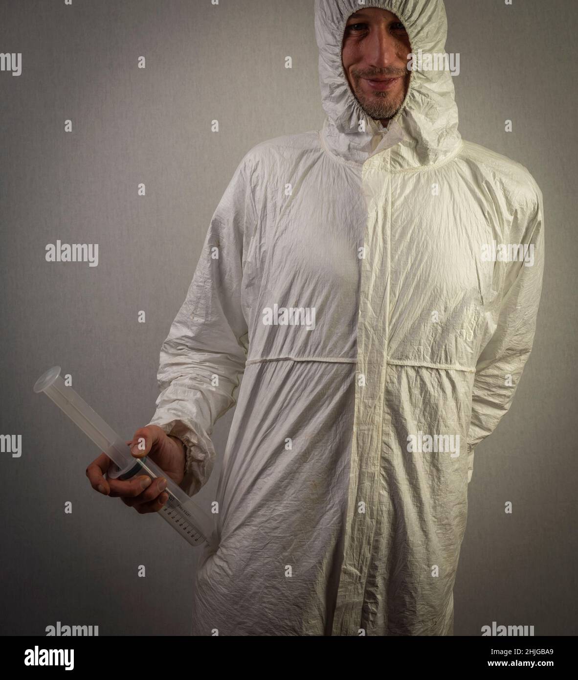 Man with white protection suit and big shot injection with white gray ...