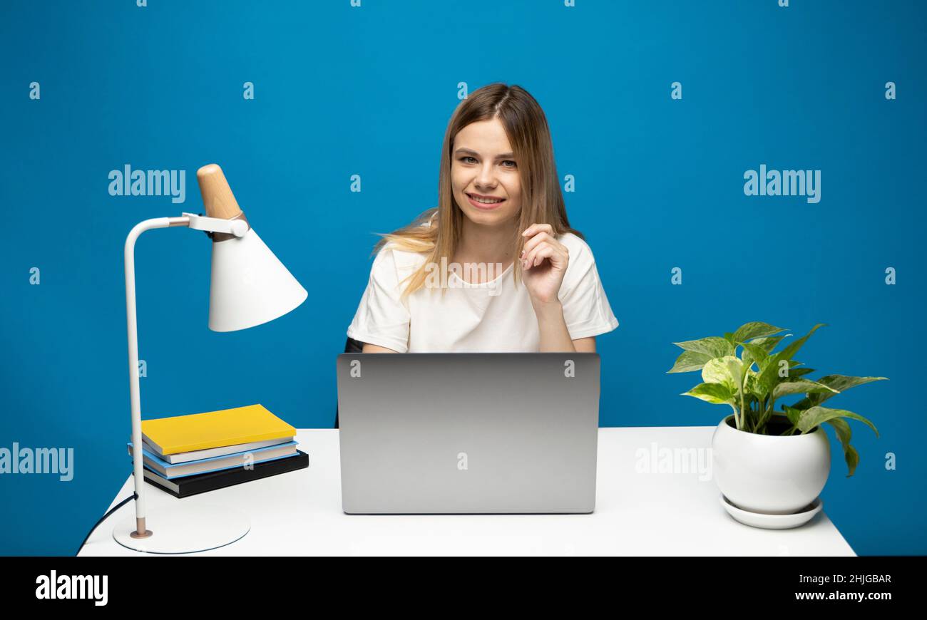 Portrait of a pretty young woman studying while sitting at the table ...