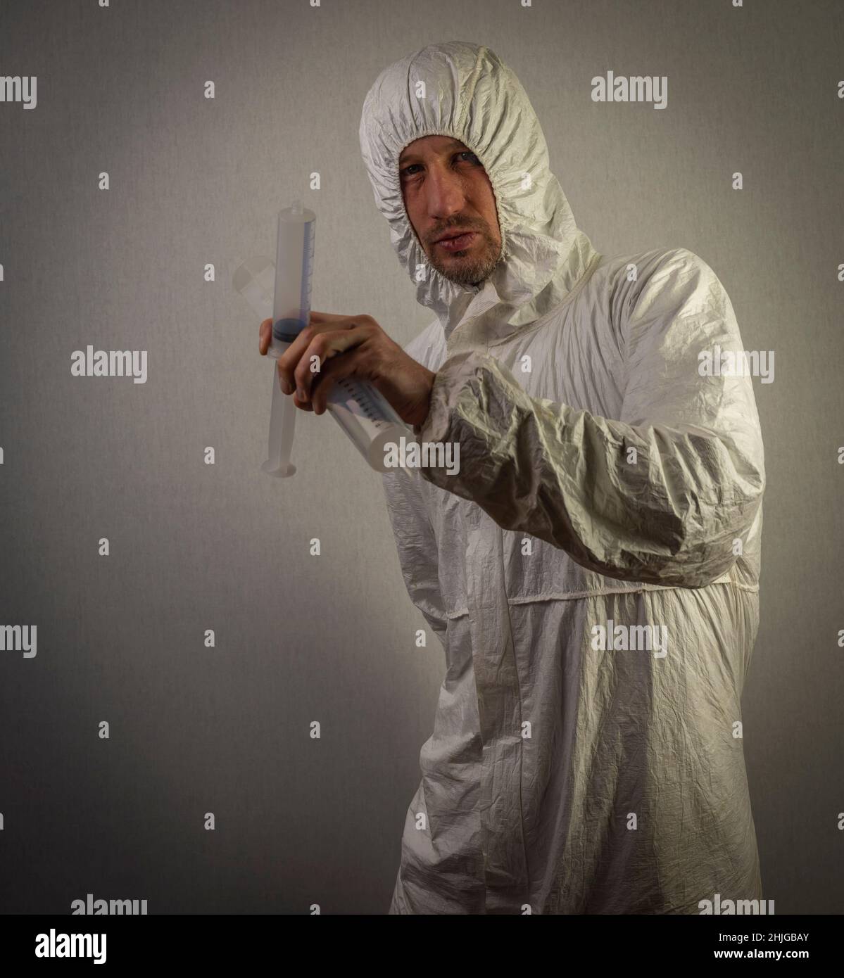 Man with white protection suit and big shot injection with white gray ...