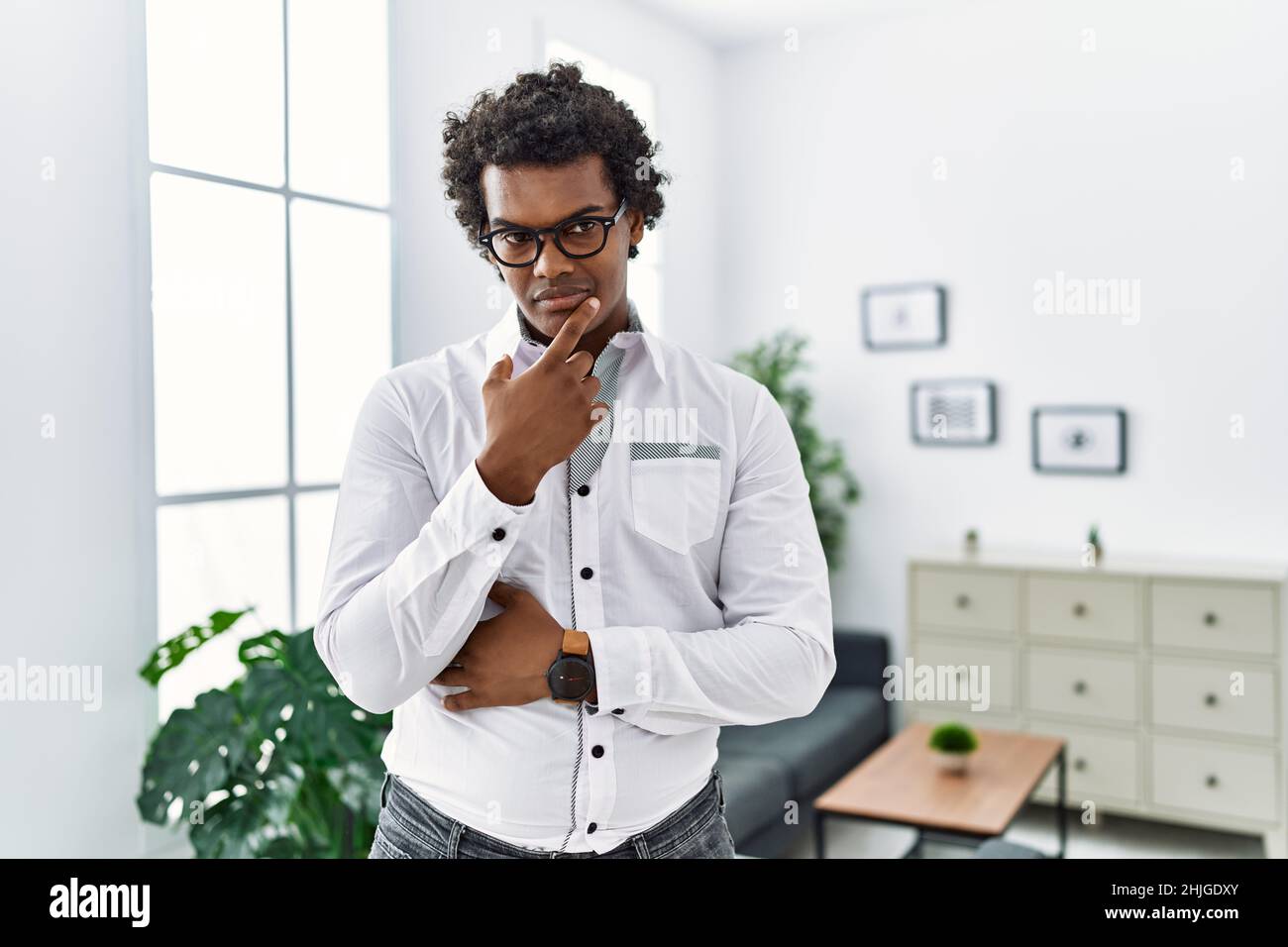 African psychologist man at consultation office thinking looking tired ...