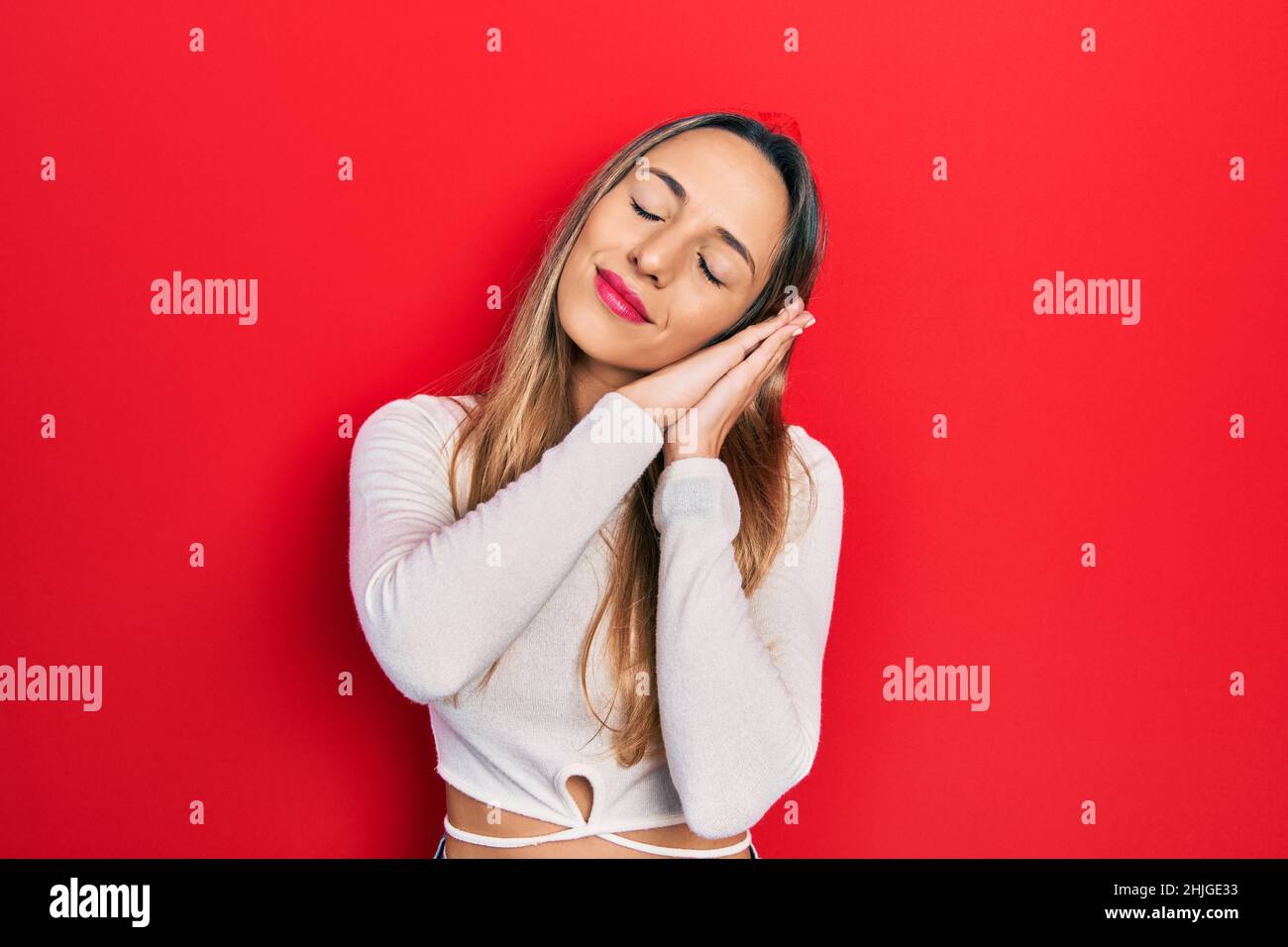 Beautiful hispanic woman wearing red diadem sleeping tired dreaming and ...