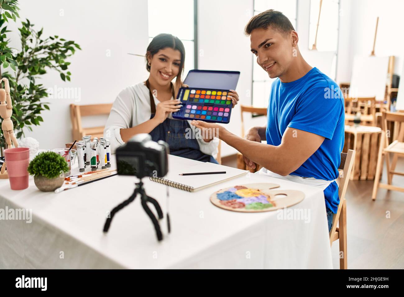 Two students smiling happy recording paint class using camera at art ...