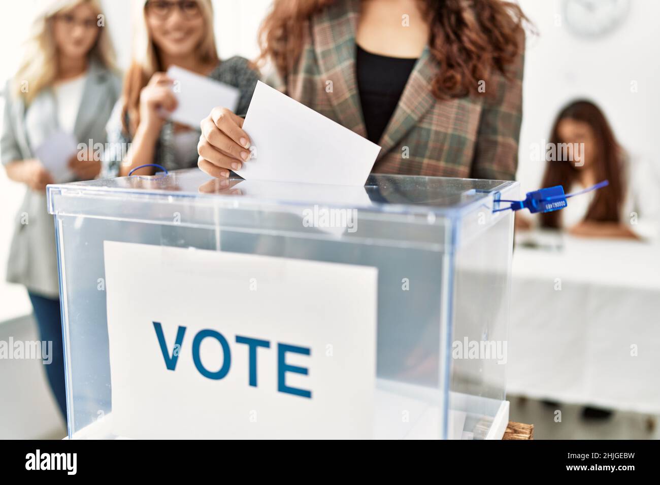 Group of young voter woman smiling happy putting vote in voting box at ...