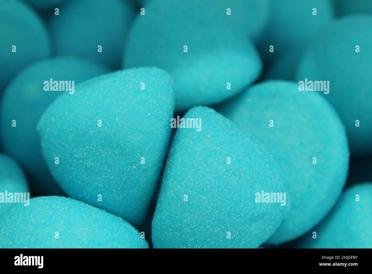 chewy blue-colored marmalade gumme shaped candy sphere truffles close ...