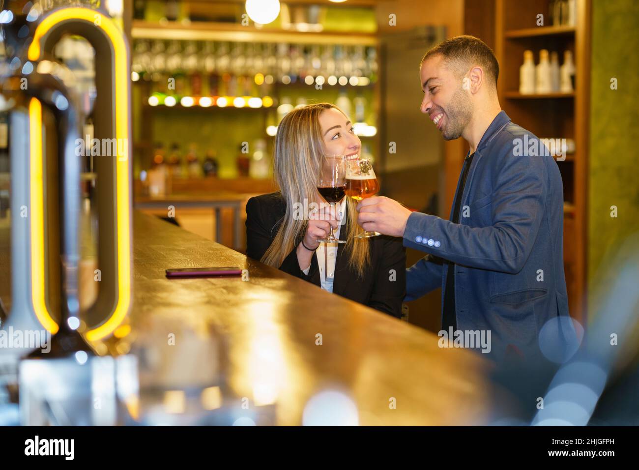 Multiethnic couple proposing toast in a pub Stock Photo - Alamy