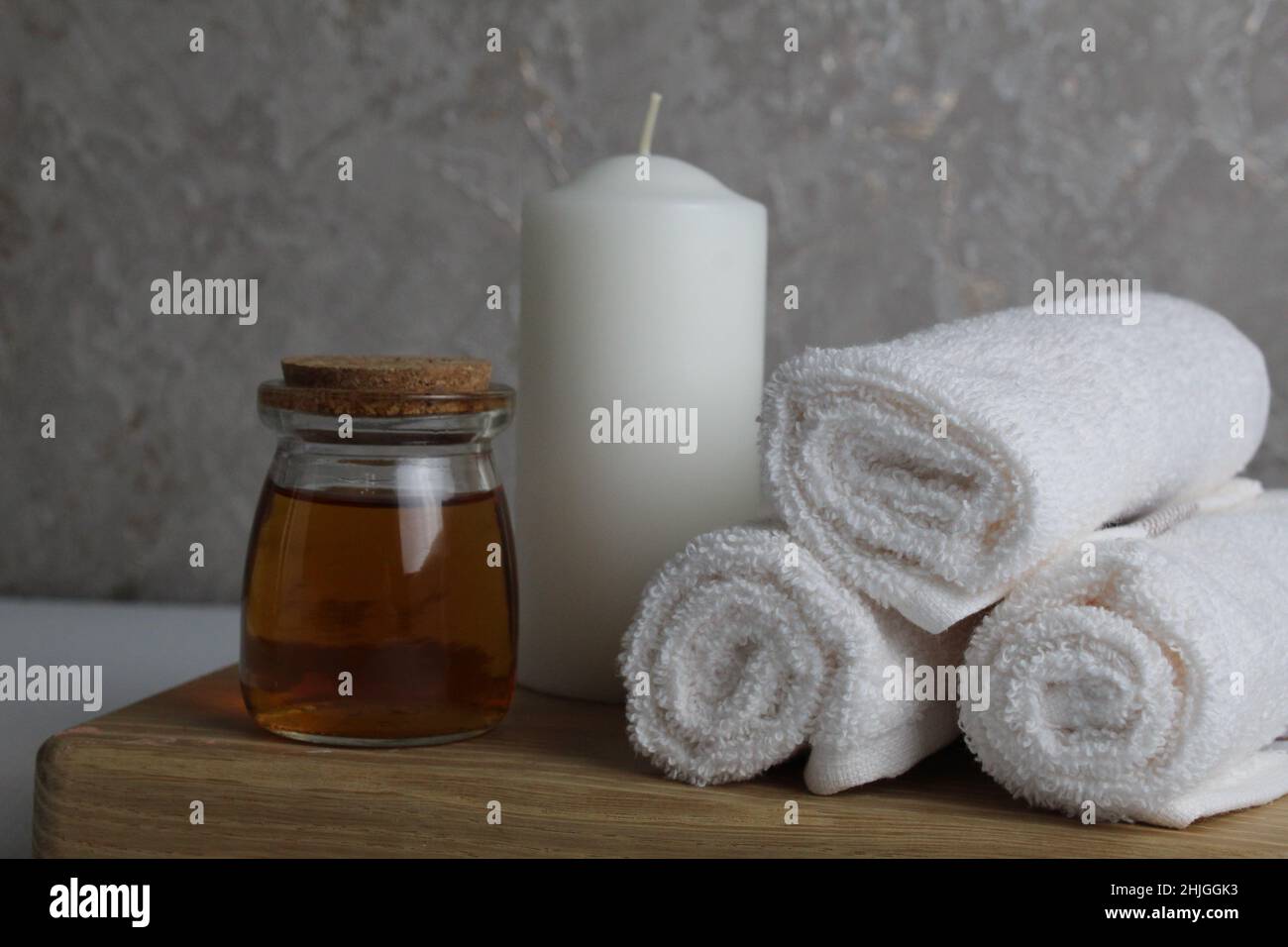oil for body massage white candle towels snail on a wooden tray on a ...
