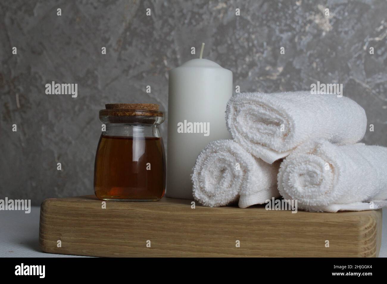 oil for body massage white candle towels snail on a wooden tray on a ...