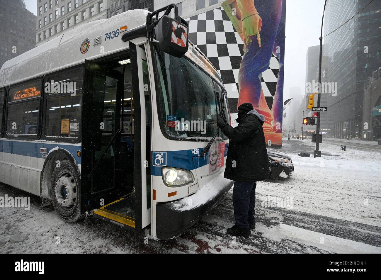 New York, USA. 29th Jan, 2022. An MTA bus driver clears his windshield ...