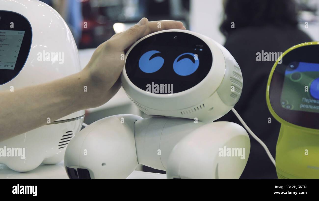 Hand of man touches the robot. Robot is happy with the touch of a human ...