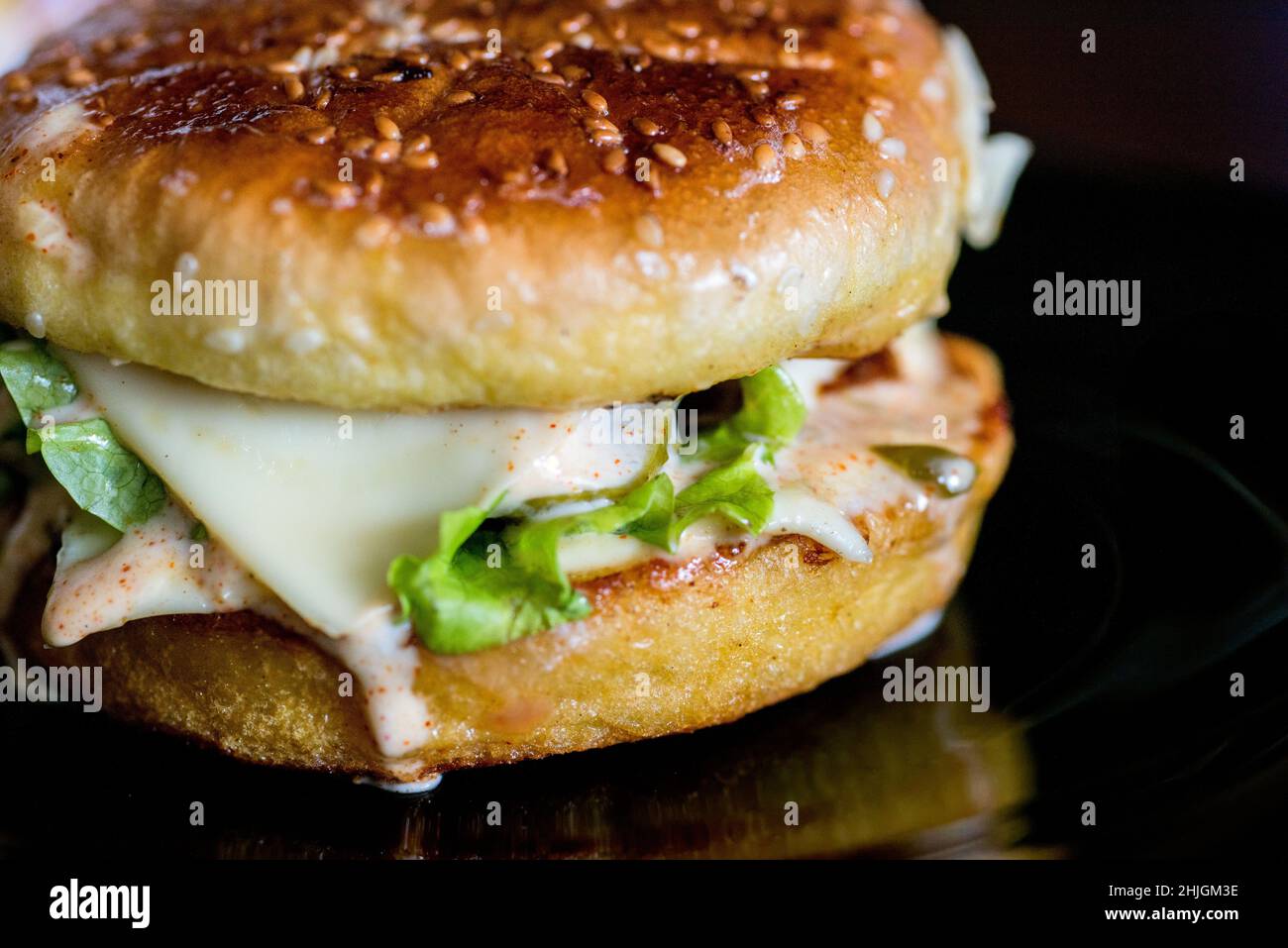 Burger with appetizing crust on a dark background Stock Photo - Alamy