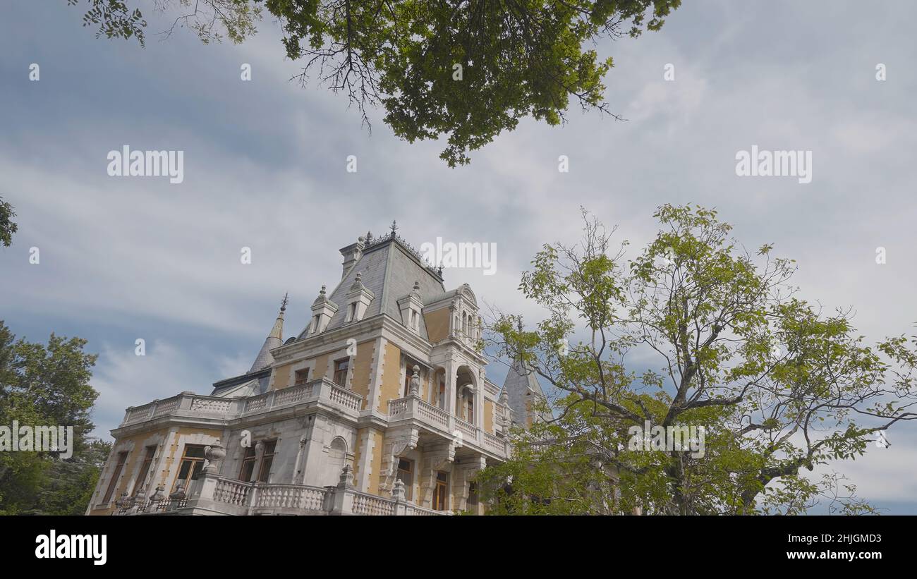 Beautiful facade of European palace on background of trees and sky ...
