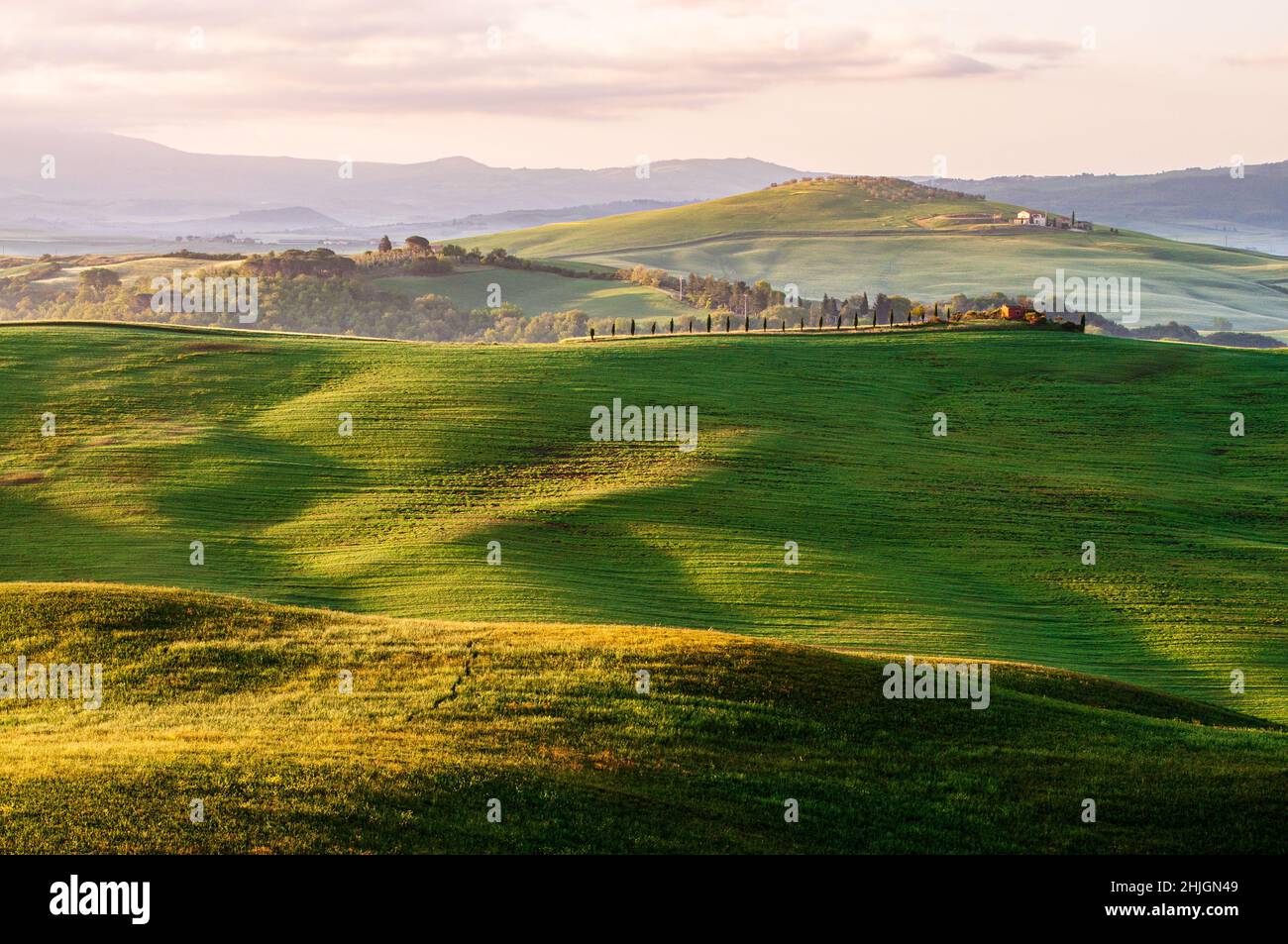Spring Tuscany. View of the green fields lit by the rays of the sun ...