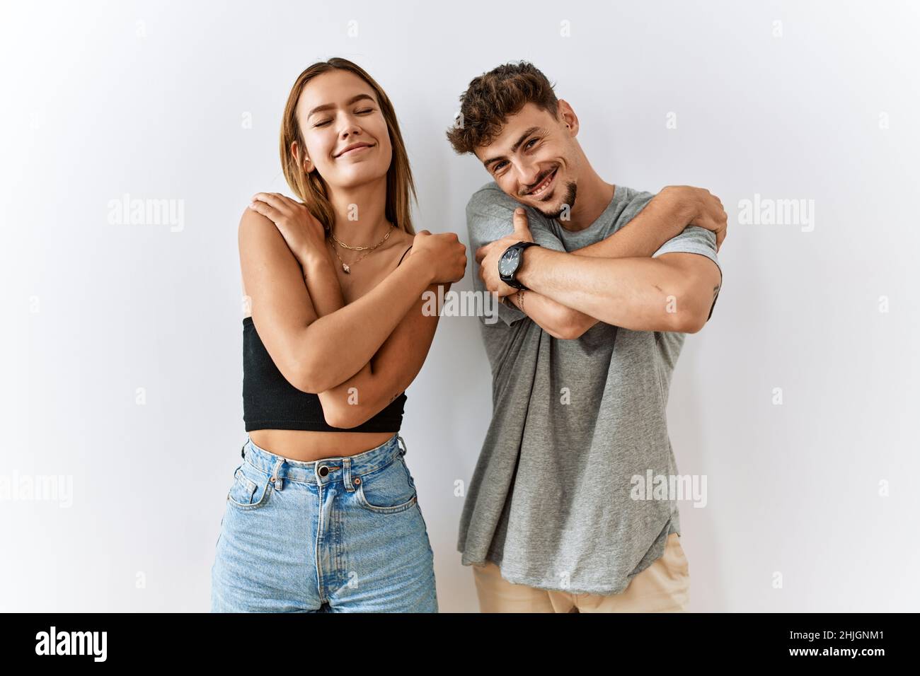 Young beautiful couple standing together over isolated background ...