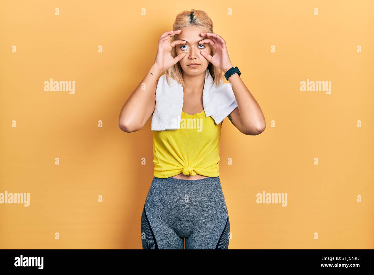 Beautiful blonde sports woman wearing workout outfit trying to open ...