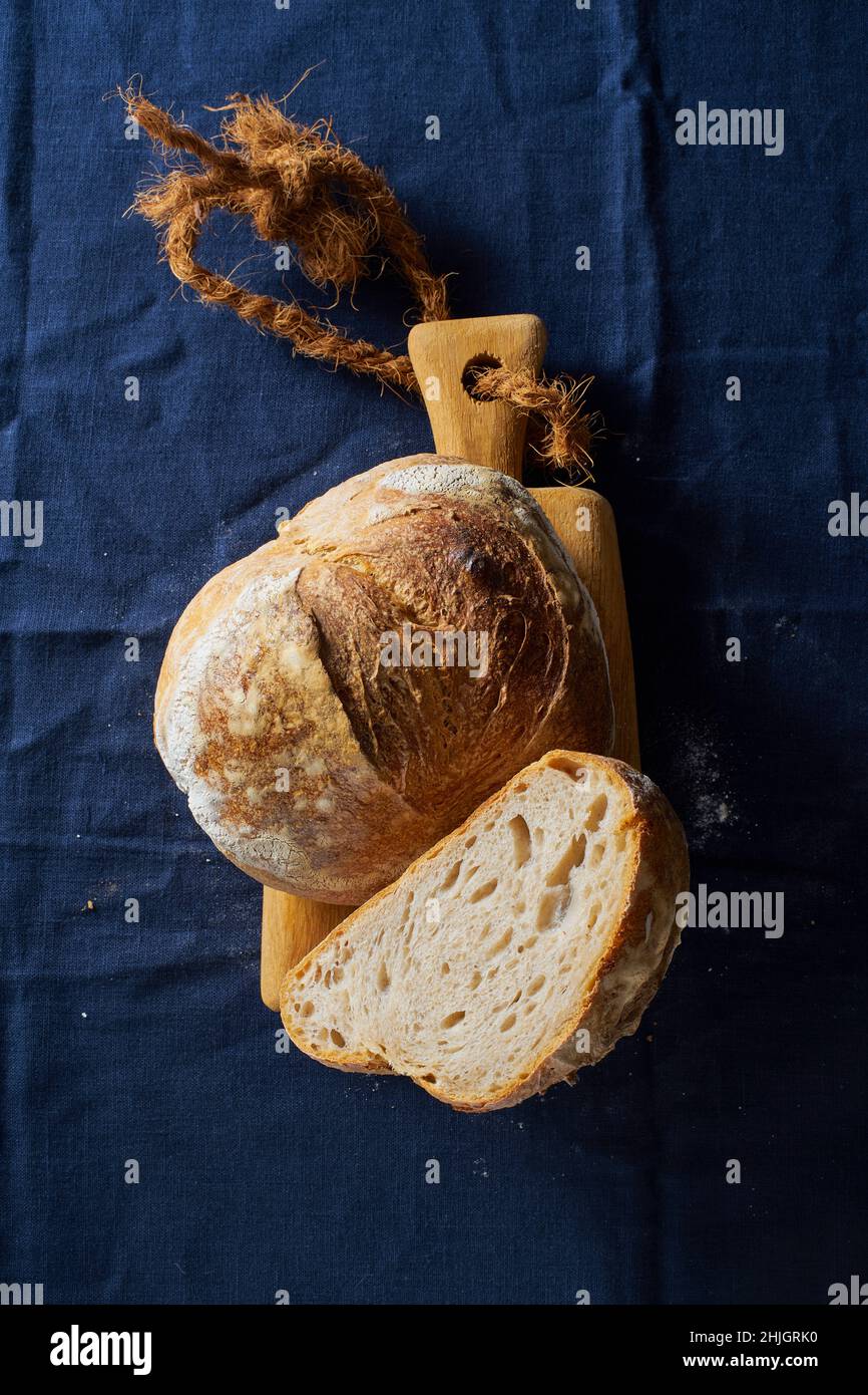 Flat lay with sourdough white bread loaves on blue linen Stock Photo ...