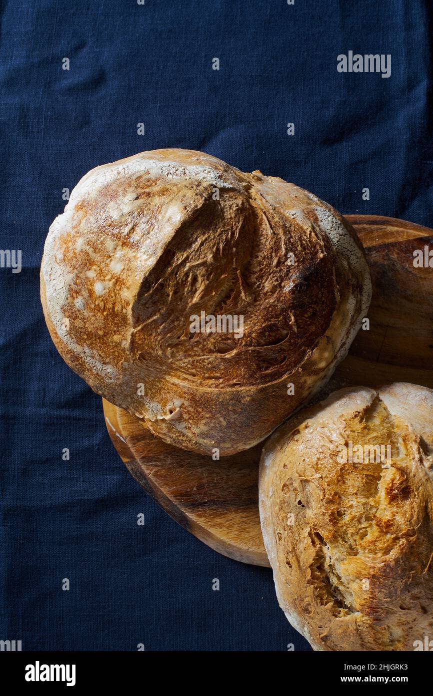 Flat lay with sourdough white bread loaves on blue linen Stock Photo ...