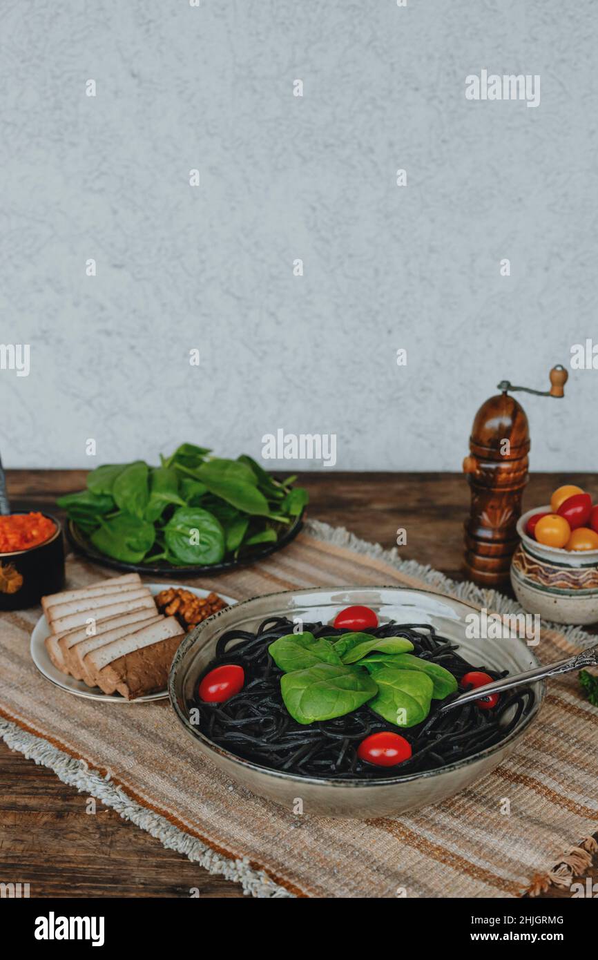 Cooked spaghetti with cuttlefish ink arranged with cheese and ...