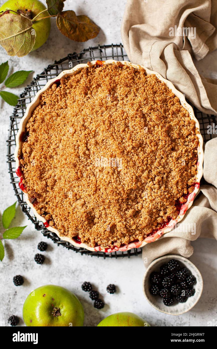 A freshly cooked fruit crumble in a serving dish, yet to be cut into ...