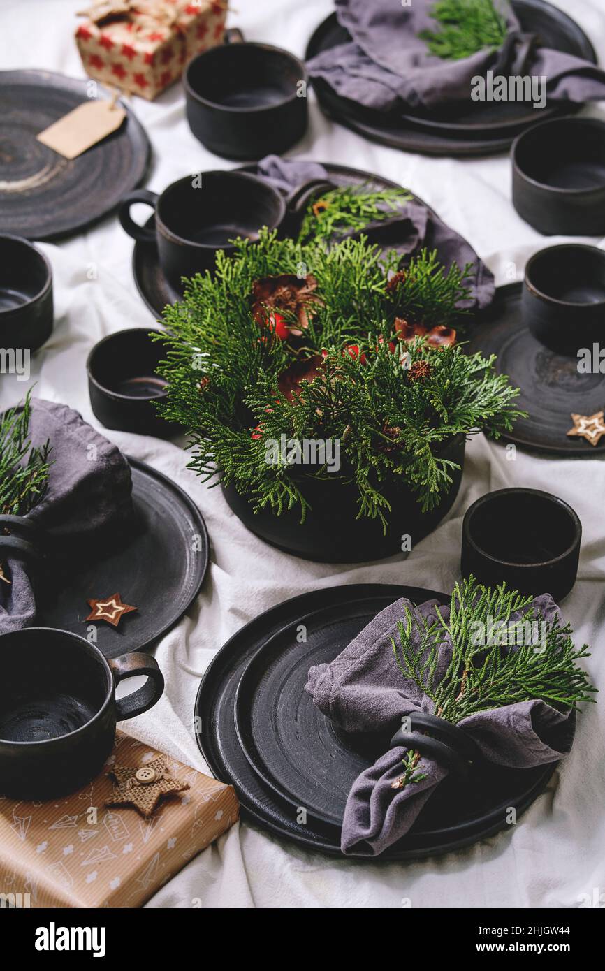 Christmas table setting with empty black craft ceramic tableware ...