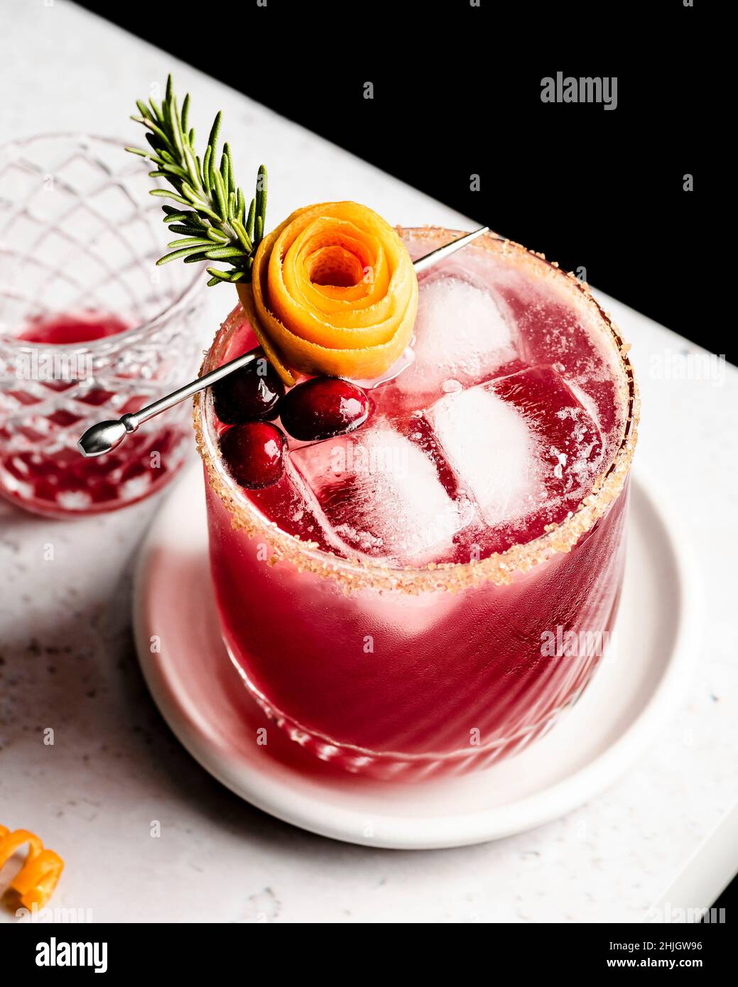 Cranberry orange margarita on the edge of a counter with an orange peel ...
